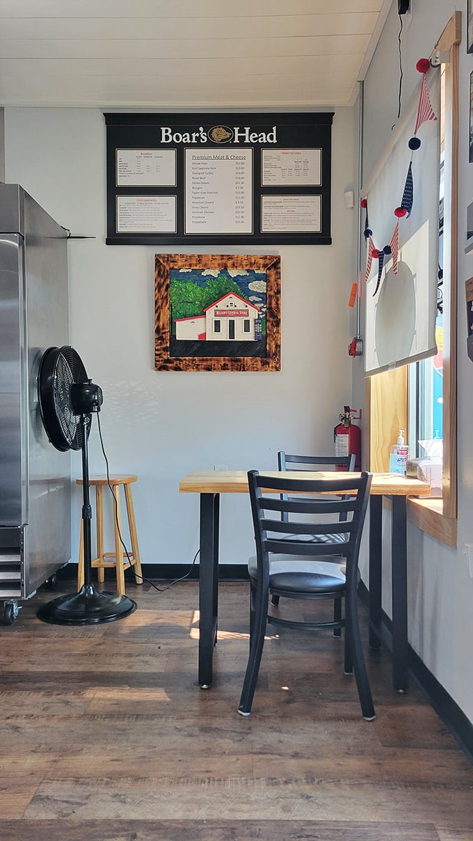 A simple wooden table and chair await beneath the Boar's Head sign&mdash;a modest throne for sandwich royalty in this unassuming temple of flavor.