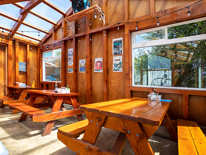 Rustic wooden picnic tables bathed in natural light create that perfect "I've discovered something special" atmosphere that makes a meal memorable.