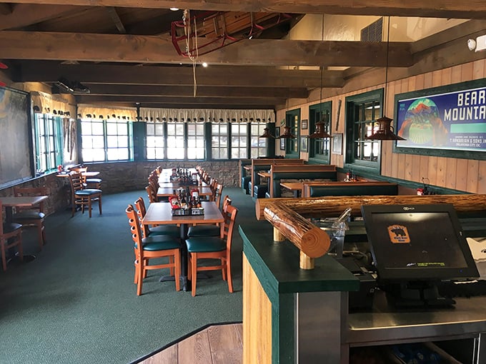 Rustic wooden beams, forest-green booths, and mountain lodge vibes create the perfect backdrop for serious comfort food consumption.