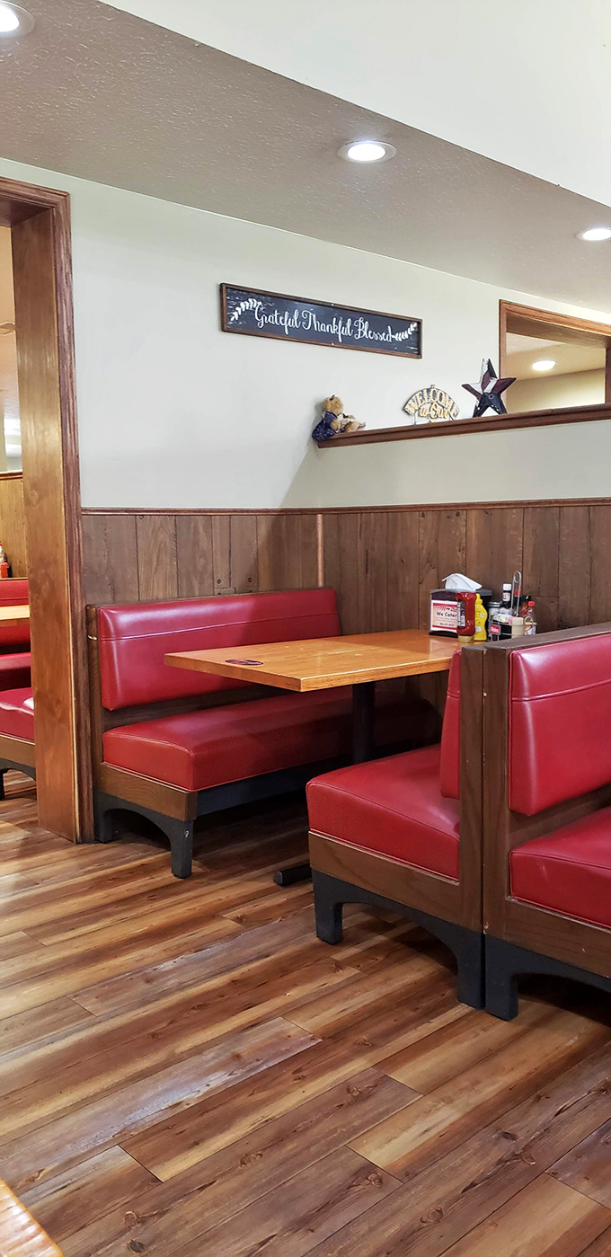 Classic red vinyl booths and wood paneling create that timeless diner atmosphere where comfort begins before the food even arrives.
