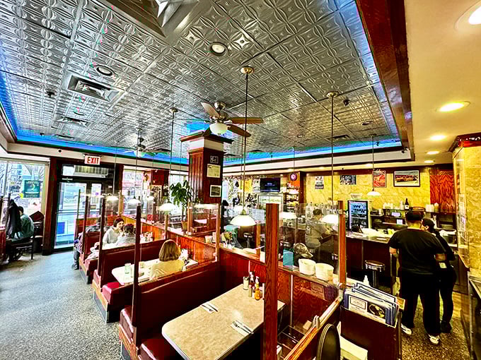 Inside, the pressed tin ceiling and wood-paneled booths create that perfect diner atmosphere where comfort food and conversation flow equally freely.