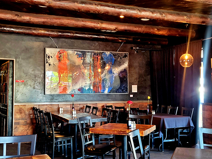 Exposed beams, moody lighting, and vibrant art create the perfect prohibition-era atmosphere. Al Capone would approve of this dining room's discrete charm.