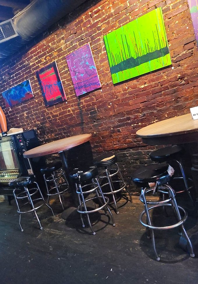 Vibrant local art pops against exposed brick walls&mdash;this isn't decoration, it's the tavern's beating heart and visual conversation.