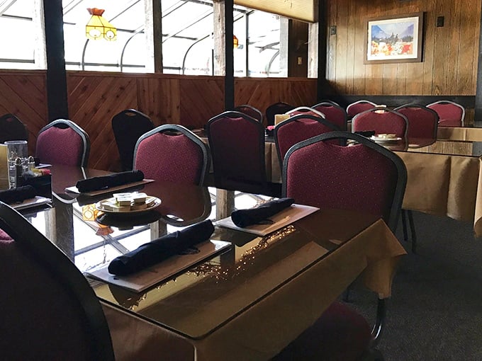 Classic red upholstered chairs and wooden paneling create that perfect time-honored steakhouse ambiance where memories are made between bites of perfectly aged beef.