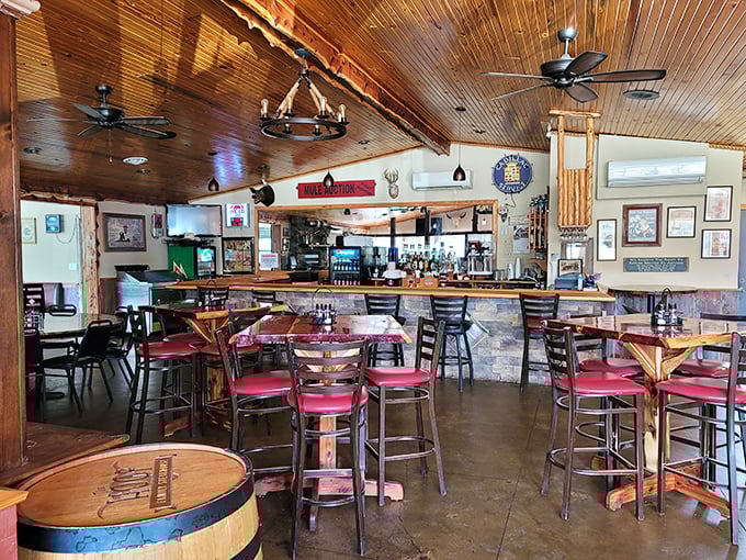 Rustic wooden ceilings, stone accents, and red bar stools create that perfect blend of country charm and steakhouse sophistication.