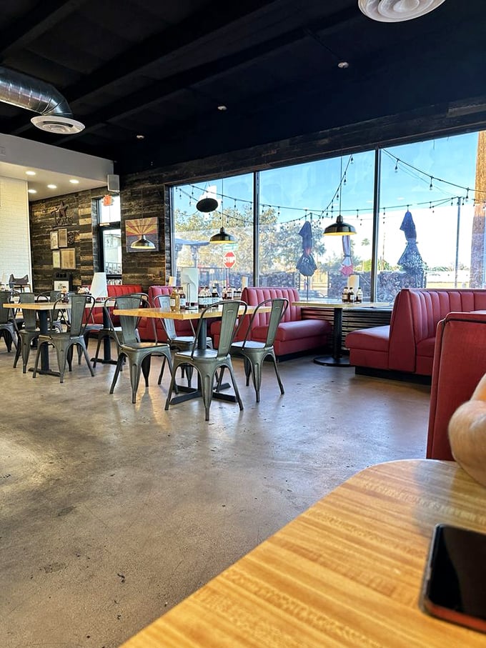 Red booths, industrial chairs, and string lights create that perfect "come as you are" atmosphere where the only dress code is an elastic waistband.