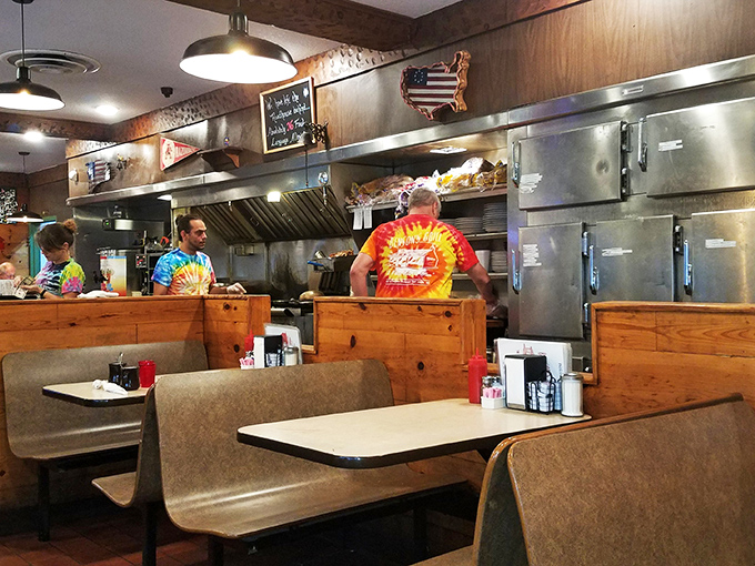Where breakfast magic happens! The open kitchen design lets you witness the choreography of short-order cooking while tie-dye shirts add unexpected splashes of color.