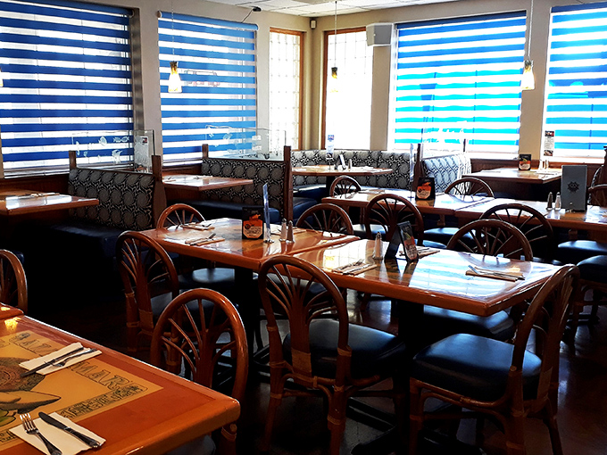 Blue-striped window treatments filter desert sunlight into ocean-like waves across comfortable wooden tables. Dining here feels like a coastal getaway.