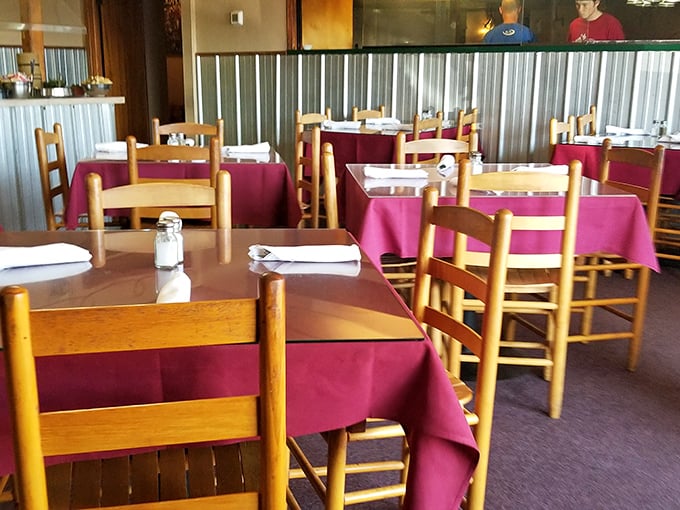 Burgundy tablecloths and wooden chairs create that classic steakhouse vibe where conversations flow as freely as the iced tea.