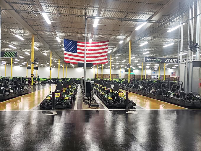 Lined up like obedient soldiers, these electric beasts wait for their next commanders. The American flag watches over the starting grid with patriotic approval.