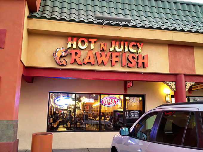 Hot N Juicy's neon sign glows like a beacon for spice-seekers. Inside, plastic gloves become your most essential fashion accessory.