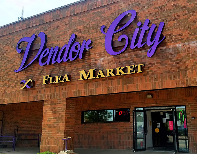 Bold purple script against weathered brick&mdash;visual shorthand for "prepare your wallet and clear trunk space." Treasures await behind those doors.
