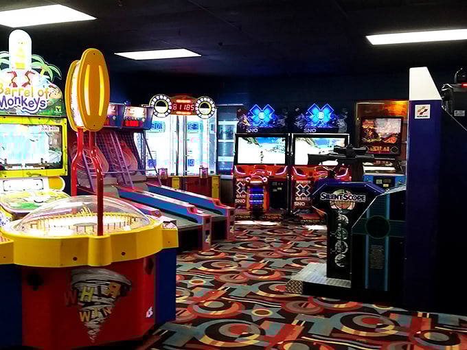 The arcade area glows with neon promise, where skee-ball champions are made and quarters disappear faster than bowling pins after a strike.