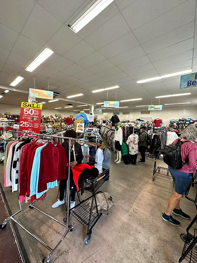 Clothing racks create a textile maze where vintage band tees and designer labels play hide-and-seek with savvy shoppers.