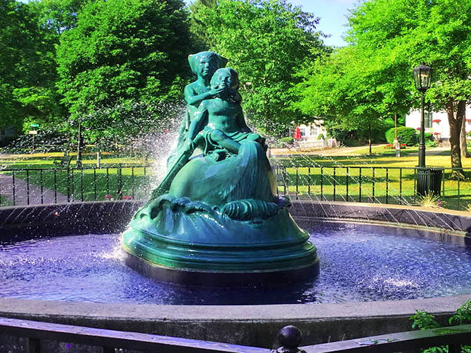The Wynken, Blynken and Nod fountain stands as the jewel of Wellsboro's town green, its emerald patina glowing against the dancing waters.