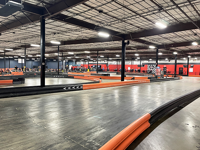 Racing paradise under industrial ceilings. The sprawling track's orange barriers guide drivers through a labyrinth of challenging turns and straightaways.