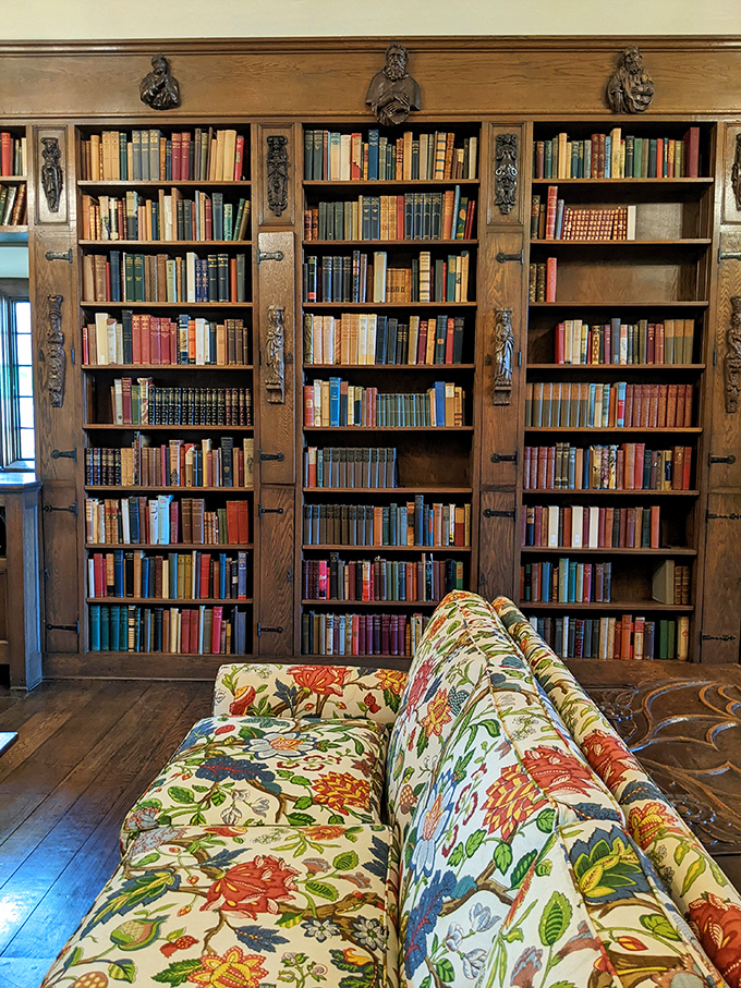 A bibliophile's dream come true: floor-to-ceiling shelves housing rare volumes, with carved figures standing guard over literary treasures.