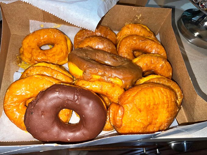 The holy grail of breakfast indulgence: a box of Round Rock's signature orange-hued donuts, with that lone chocolate-covered rebel stealing the spotlight.