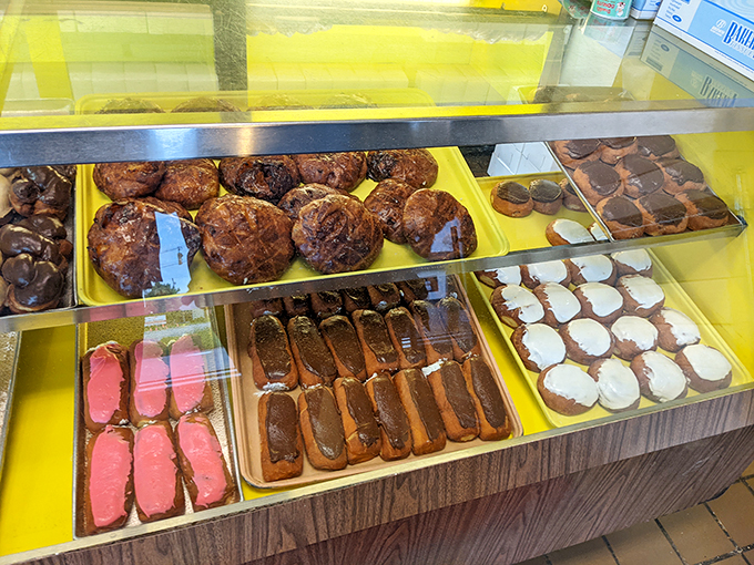 The display case&mdash;a museum of donut artistry where life's biggest decision becomes "glazed or chocolate?" Both is always the correct answer.