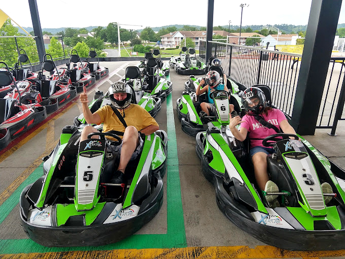 The starting grid—where ordinary folks transform into racing heroes, their colorful helmets masking the mix of terror and glee beneath.