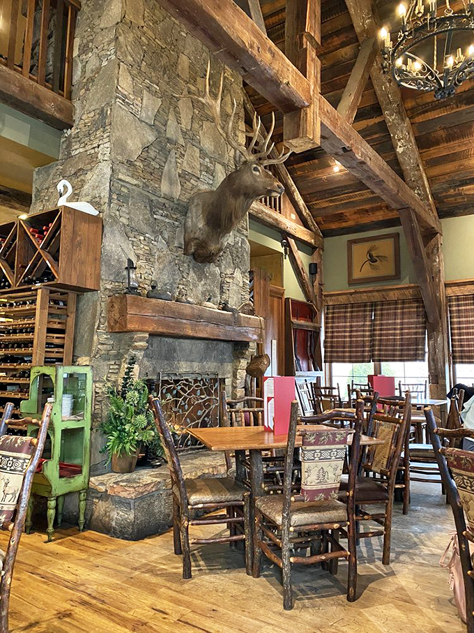 That fireplace could tell stories. Massive stone, soaring timbers, and yes, a watchful elk&mdash;this dining room feels like a millionaire's mountain lodge.