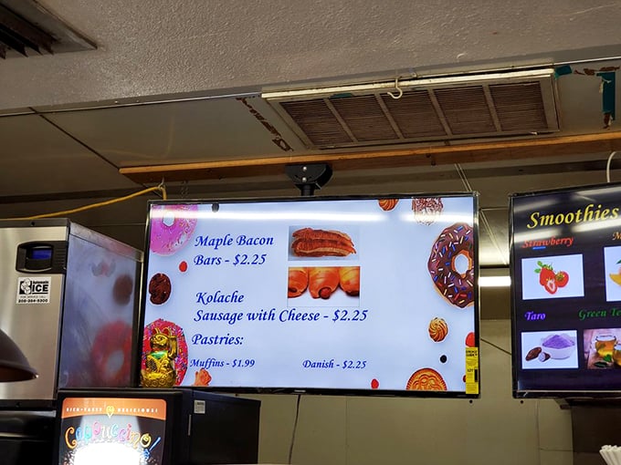 The menu board speaks the universal language of comfort: maple bacon bars and kolaches that could make a cardiologist weep with joy.