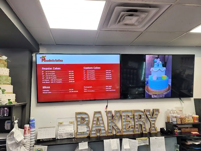 The digital menu board showcases their cake specialties, where celebrations are measured in layers, frosting, and the inevitable "just one more slice."