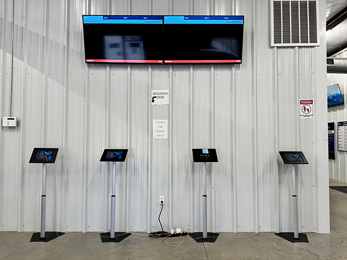 Modern tech meets motorsport at the registration area. Those screens will soon display your lap times&mdash;and possibly shatter your racing delusions.