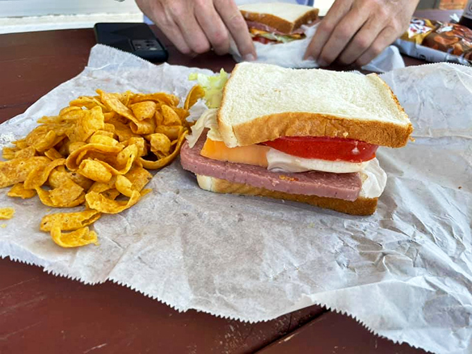 This isn't just a sandwich; it's edible nostalgia with thick-cut bologna, sharp cheese, fresh veggies, and chips that crunch like childhood memories.
