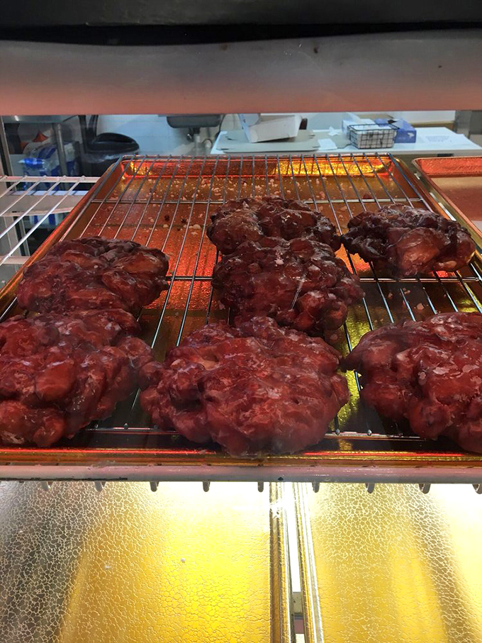 Fresh apple fritters cooling on the rack&mdash;craggily, golden-brown masterpieces waiting to make someone's morning exponentially better.