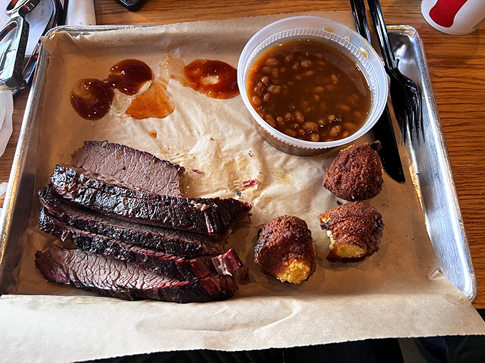 Brisket cut thick with textbook bark and that pink smoke ring that makes barbecue aficionados weak in the knees. Hush puppies standing by.