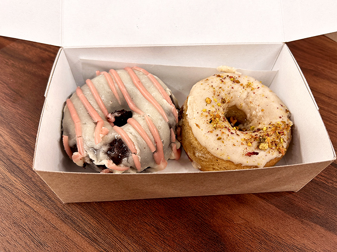 A trio of circular joy nestled in a takeout box—proof that the best things in life sometimes come in cardboard containers with sprinkles.
