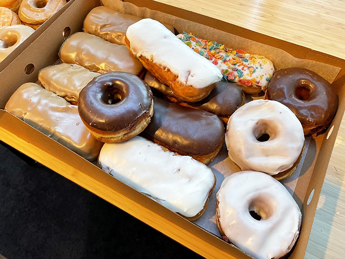 -Donut democracy in action &ndash; a dozen different personalities sharing one box. The twisted glazed ones are practically doing the backstroke in suga==r.