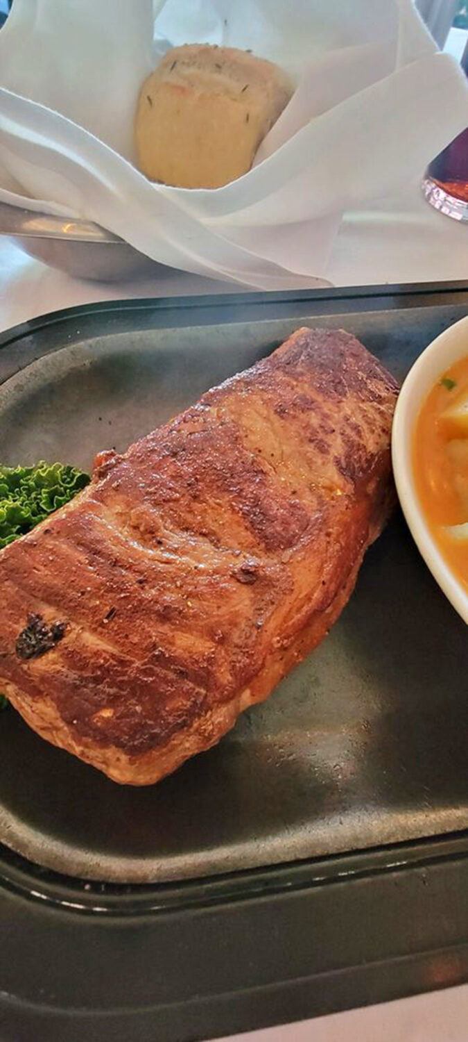 The perfectly seared New York strip arrives with sauce being poured like liquid gold&mdash;a meat masterpiece getting its final brushstroke.