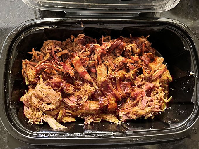 Pulled pork in its natural habitat&mdash;ready for the journey home. This container holds enough smoky treasure to make your kitchen smell like heaven.