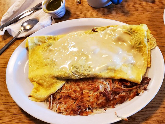This isn't just an omelet, it's architecture. Golden peaks of egg draped over savory filling, with hash browns that achieve the holy grail of crispy-outside-fluffy-inside.