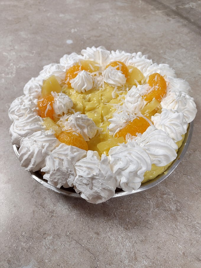 Behold the tropical cream pie, where whipped cream peaks frame fruit like a delicious landscape painting you can actually eat.