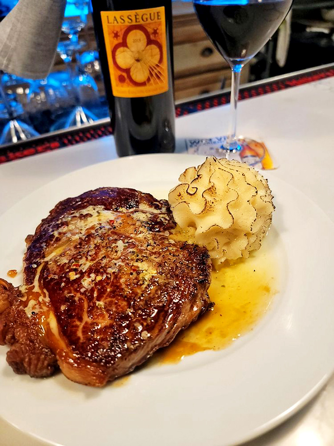 This isn't just a ribeye&mdash;it's a master class in beef appreciation. That crust whispers tales of perfect heat while that wine stands by, ready to complete the romance.