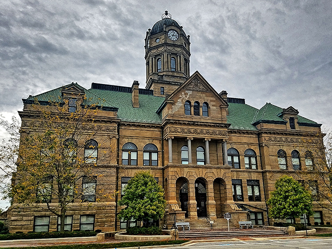 The Auglaize County Courthouse stands as a sandstone sentinel of justice, its clock tower keeping watch over the town since 1894.