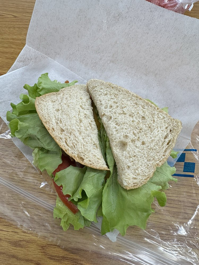 Fresh lettuce spills over the edges of this BLT, proving that simple ingredients treated with respect can create sandwich perfection.