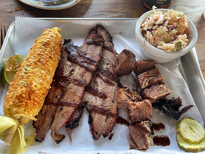 Brisket sliced with the reverence it deserves, alongside corn and slaw. This isn't just dinner; it's a religious experience with napkins.