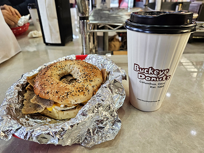 The everything bagel breakfast sandwich, wrapped in its silver foil throne, ready to transform your morning from mundane to magnificent.