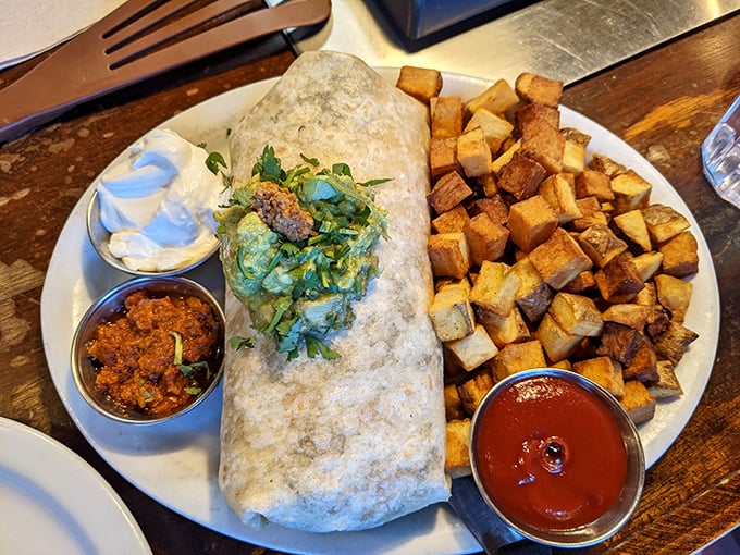 Behold the breakfast burrito in its natural habitat—flanked by perfectly crispy home fries and awaiting its inevitable meeting with your face.