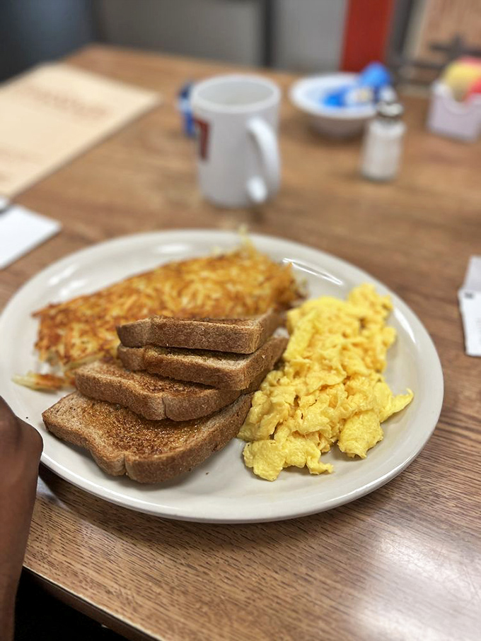 Breakfast perfection on a plate: golden hash browns, fluffy scrambled eggs, and toast that's actually toasted properly. The holy trinity of morning satisfaction.