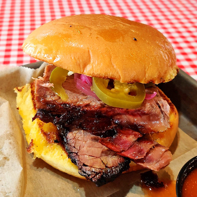 This isn't just a sandwich; it's a skyscraper of smoked brisket where pickled jalape&ntilde;os and onions cut through the richness like flavor lightning.