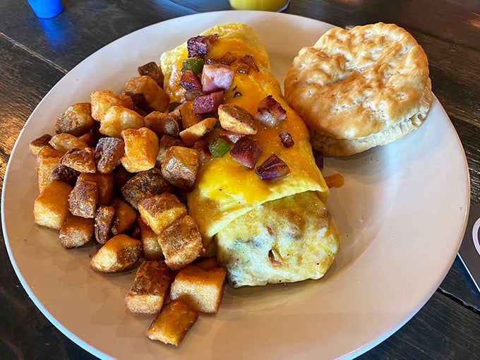 Behold the omelet that launched a thousand return visits. Perfectly folded eggs embrace their savory fillings while home fries stand guard like delicious golden sentinels.