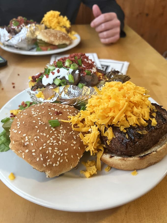 Behold the holy grail of burgers - half-pound of beefy perfection topped with a mountain of shredded cheddar that cascades like a cheese waterfall.