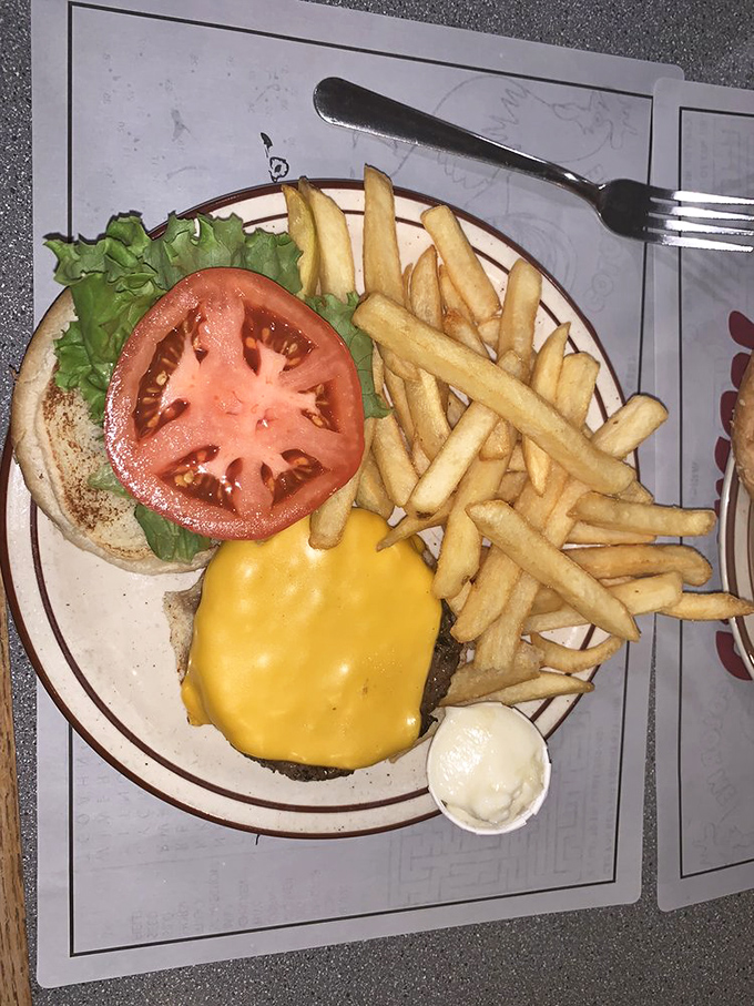 A burger so perfect it deserves its own zip code—melted cheese cascading over a fresh patty, accompanied by golden fries that could make a French chef weep with envy.