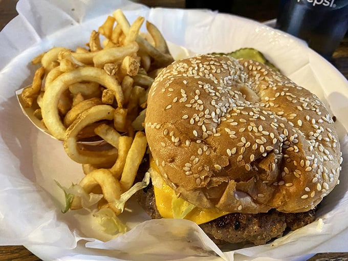 The star of the show: a golden-brown sesame bun embracing a juicy patty, with curly fries standing by for support.