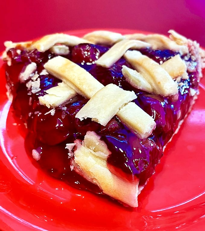 This cherry pie isn't just dessert, it's edible stained glass. The lattice crust creates windows into a ruby filling that practically demands a moment of silent appreciation.